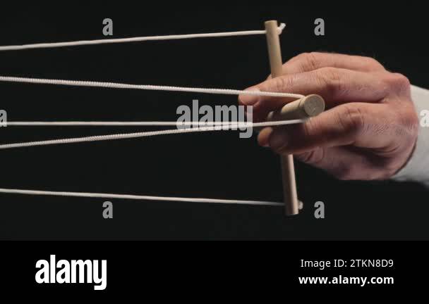 The puppeteers hand controls the puppet with a wooden manipulator and ...