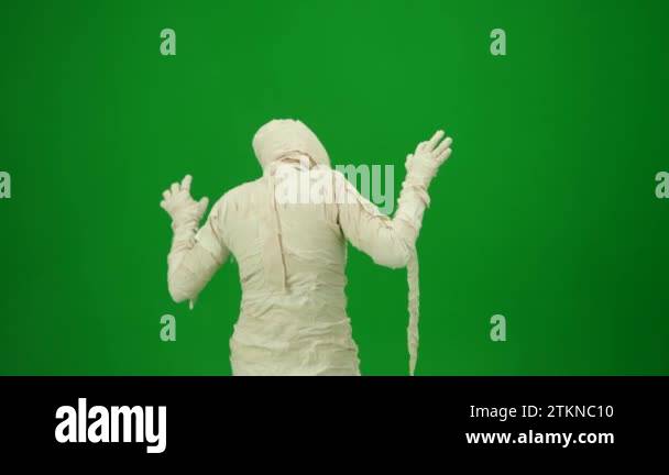 Scary mummy looks around, searches for a victim and scares with raised ...