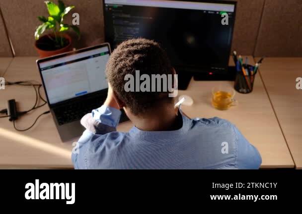 Black Man Writing Lines of Code On Desktop PC With Two Monitors and a ...