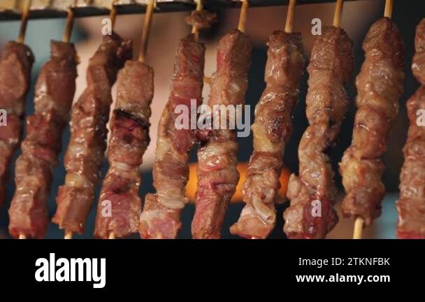 Rotating fried meat on a skewers. shashlik or Shish Kebab. close-up ...