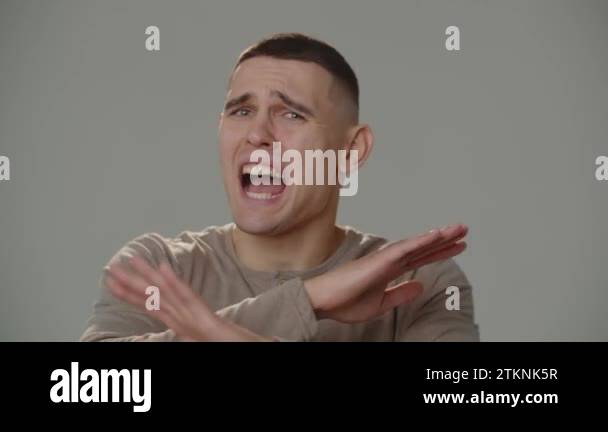 A young man looking at the camera explains something in a rude manner ...