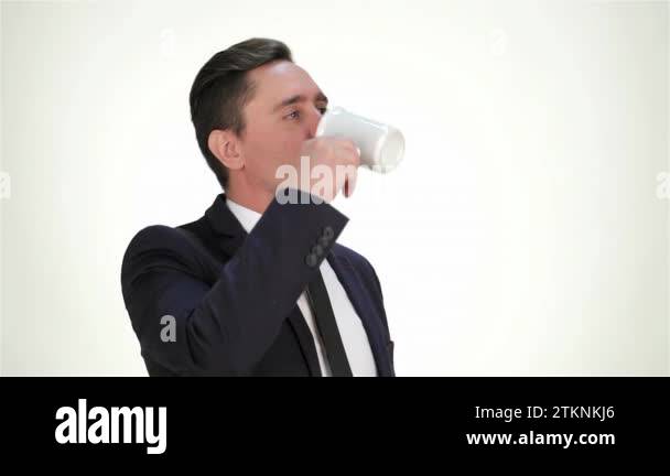 Formally dressed businessman drink from a cup, smiling and showing ...