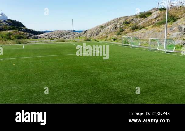 A receding shot showing a coastal football field with goal nets during ...