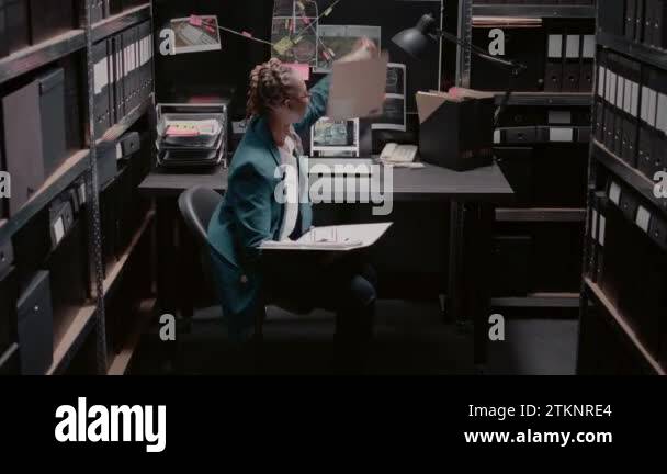 Private investigator reviewing new case evidence on detective board ...