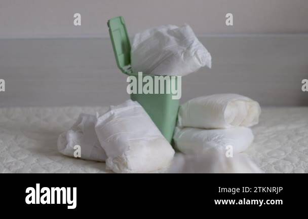 many dirty full baby diapers on floor bed or in blue trash plastic bag ...