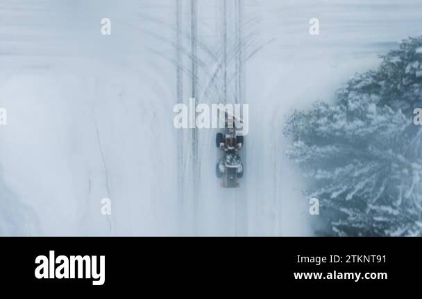 Aerial top down shot of snow ploughs driving by frosty highway covered ...
