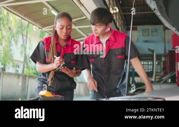 Two professional automotive mechanical partners check and repair an EV car battery and hybrid ...