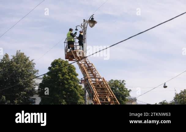 lift bucket, Municipal worker, light bulb. Worker repairing street ...