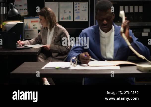 African American detective and Caucasian criminologist gather evidence ...
