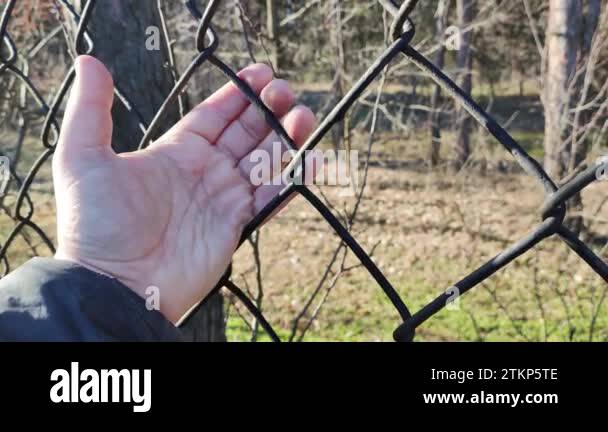 iron grate. steel mesh. the hand is holding the grate. a man's hand ...