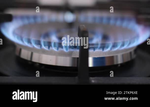 Lighting a fire on a kitchen gas stove. A close-up of the burning flame ...