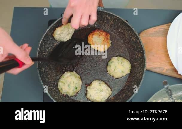 Womens hands turn vegetable cutlets from cabbage to the other side with ...
