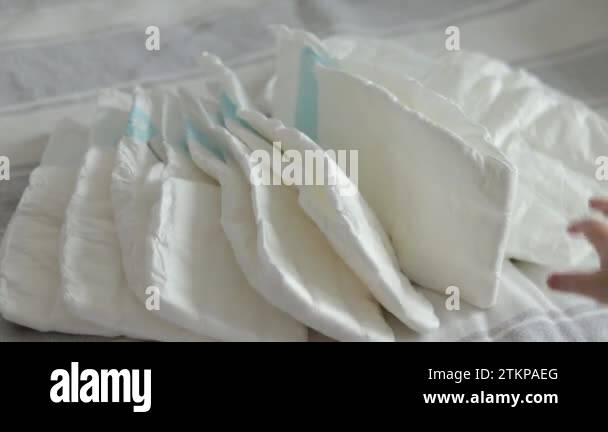 baby diapers in pack woman mother hand or bed finger counting throwing ...