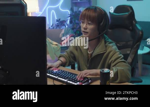 Medium shot of Asian teenage girl sitting in front of computer at home ...
