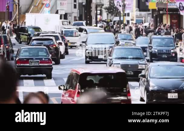 Tokyo, Japan - Oct 7,2023: Crowd of Asian people walk, car bus taxi ...