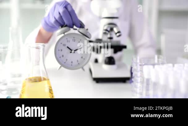 Clock with chemical glassware for medical research in laboratory in ...