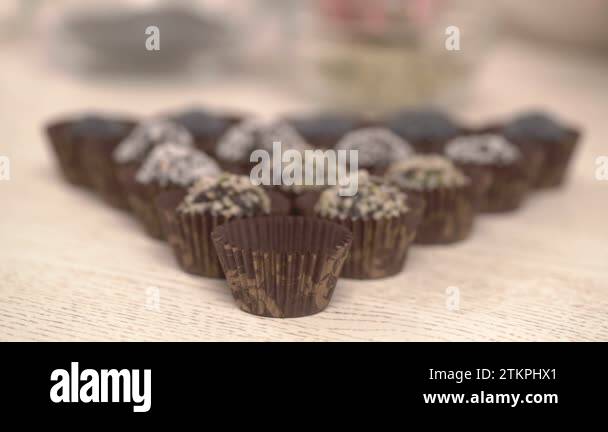 A close-up video of woman's hand holding a round chocolate candy in a ...