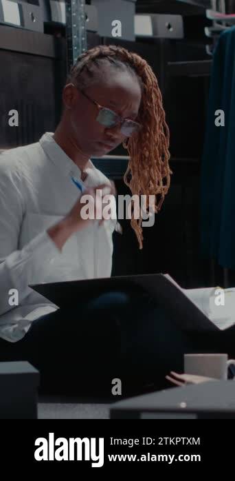 Vertical video: Female detective reading records on criminal case ...