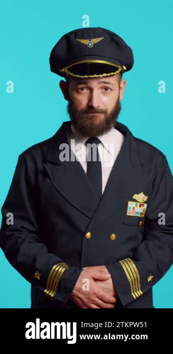 Vertical video: Male plane captain wearing airline uniform and posing ...
