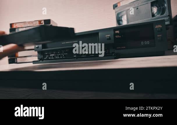 Insert VHS cassette into VCR player. Black vintage videotape cassette ...