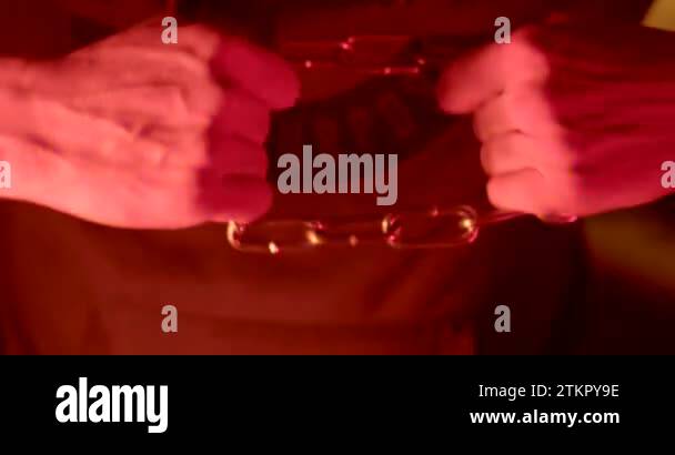 Tensioning the chain with the hands of a man in the light of police ...