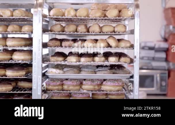 Bakery shelves keeping a lot of different types of fresh baked donuts in a shop in Los Angeles ...