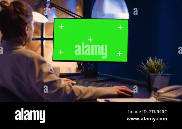 Business woman analyzing green screen display on pc, looking at ...