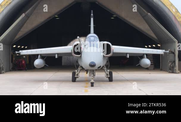 Jet fighter plane seen from the front with engine running and shelter ...