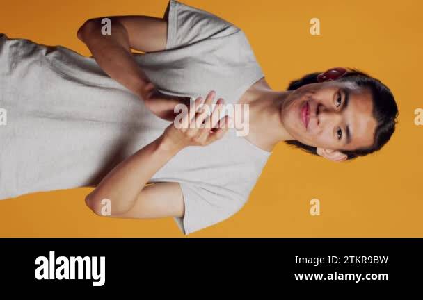 Vertical video: Smiling person clapping hands in studio, laughing and ...
