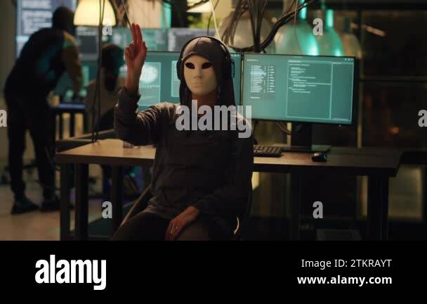 Female hacker with anonymous mask using hologram to break into firewall ...