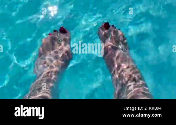 Clean blue pool water sparkles in the sun as it ripples and flows over ...