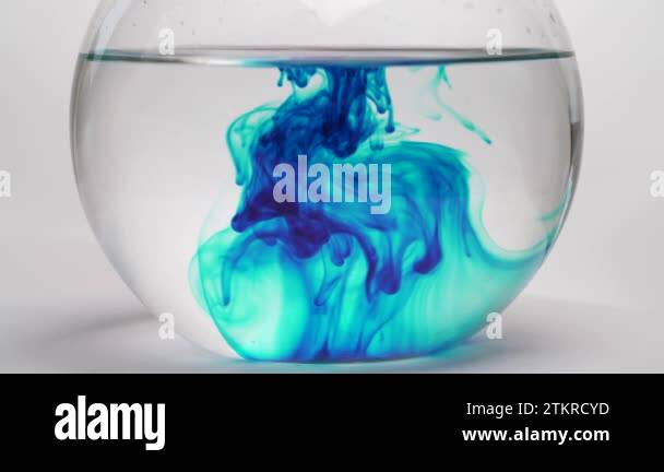 Spreading of dark blue chemical reagent into glass flask with pure ...
