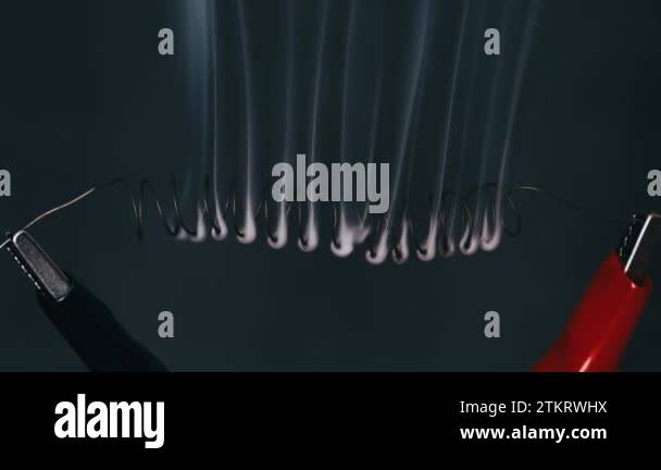 The nichrome wire heats up to red with smoke under high electric ...