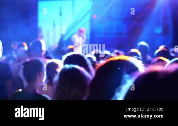 Silhouettes of crowd of people at disco which dances to good rhythmic ...