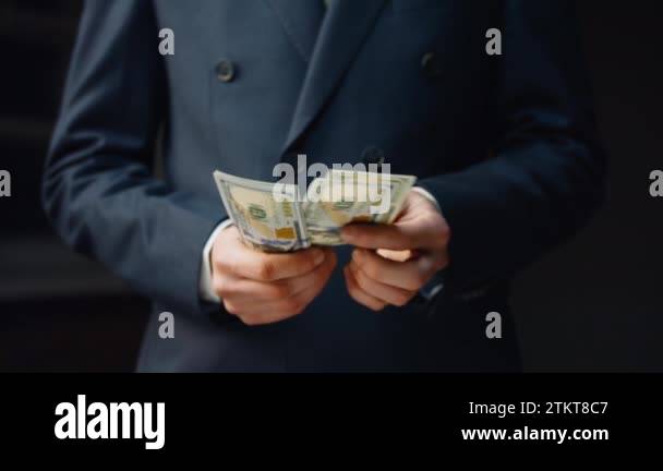 Rich elegant man counting profit wearing black luxury suit close up ...