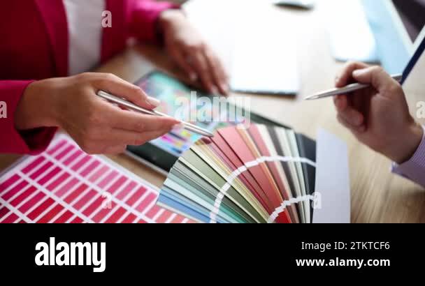 Designer advises client and shows color sample in color palette and on ...