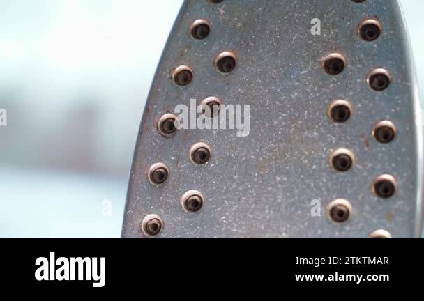 The soleplate of an old iron with channels for steam to escape. Burn ...