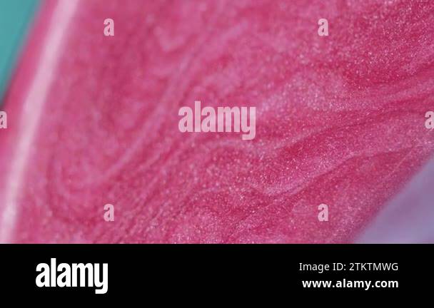 Glitter fluid. Paint flow. Enamel drip. Defocused shiny shimmering pink ...