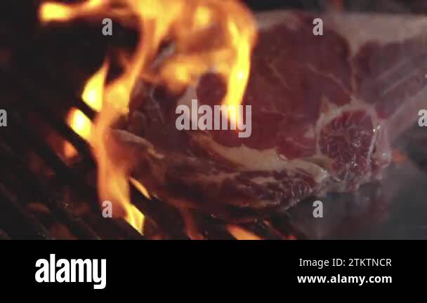 Roast beef. Beef steak on grill with flames. Rib-eye steaks cooking on ...