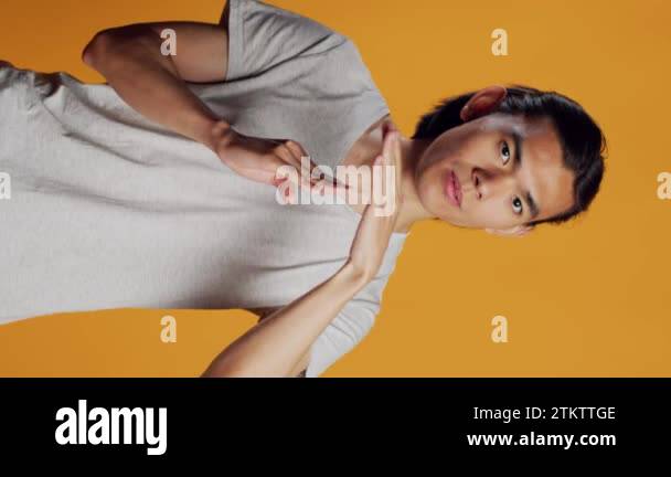 Vertical video: Young adult doing t shape symbol on camera, showing ...