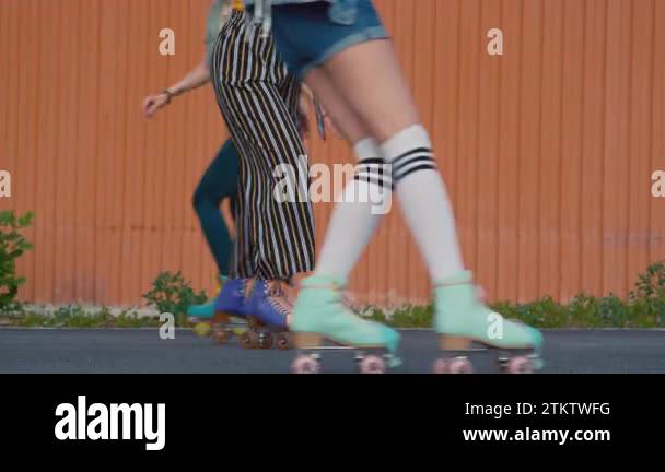 Ground level medium stable shot of three girls in retro colorful ...