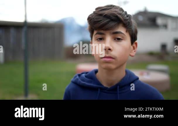Portrait of a young teenager boy standing outside. Closeup face of male ...