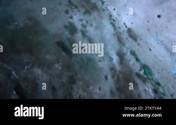 Turquoise pure color of ice inside the ice cave. Stones and icicles are ...