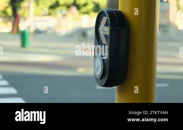 Womans hand pushing a yellow downtown city street crosswalk button ... Womans hand pushing a yellow downtown city street crosswalk button ...