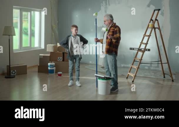 Grandpa planning repairs in apartment and explaining to his grandson ...