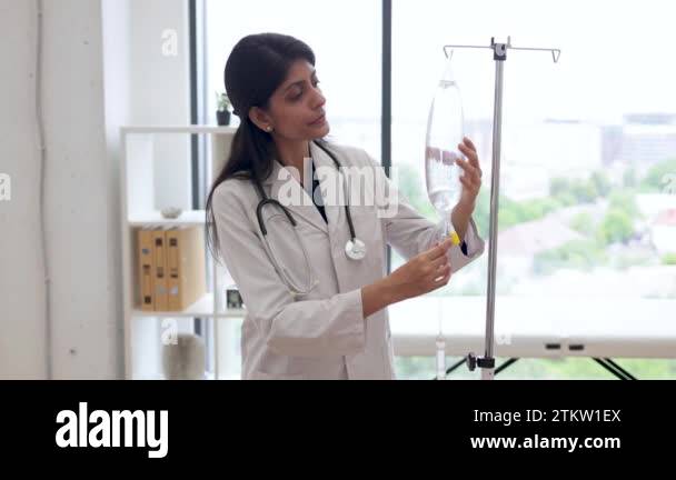 Adult female doctor in white lab coat standing near medical dropper and ...