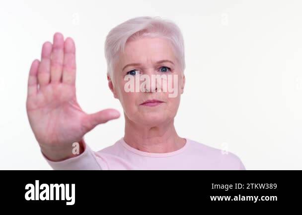 Woman confidently displays the universal stop gesture with hand, palm ...