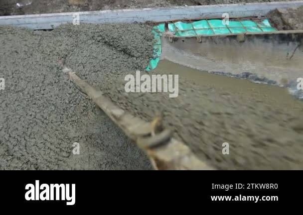 Unloading fresh concrete, pouring layer of concrete flow over ramp ...