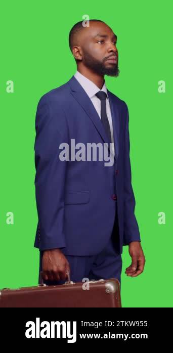 Vertical video: Side view of formal businessman carrying suitcase for ...