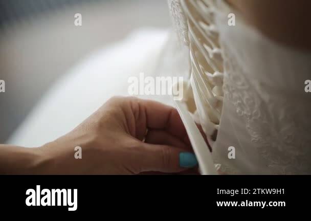 Mother helps her daughter to fasten foundation garment on her wedding ...